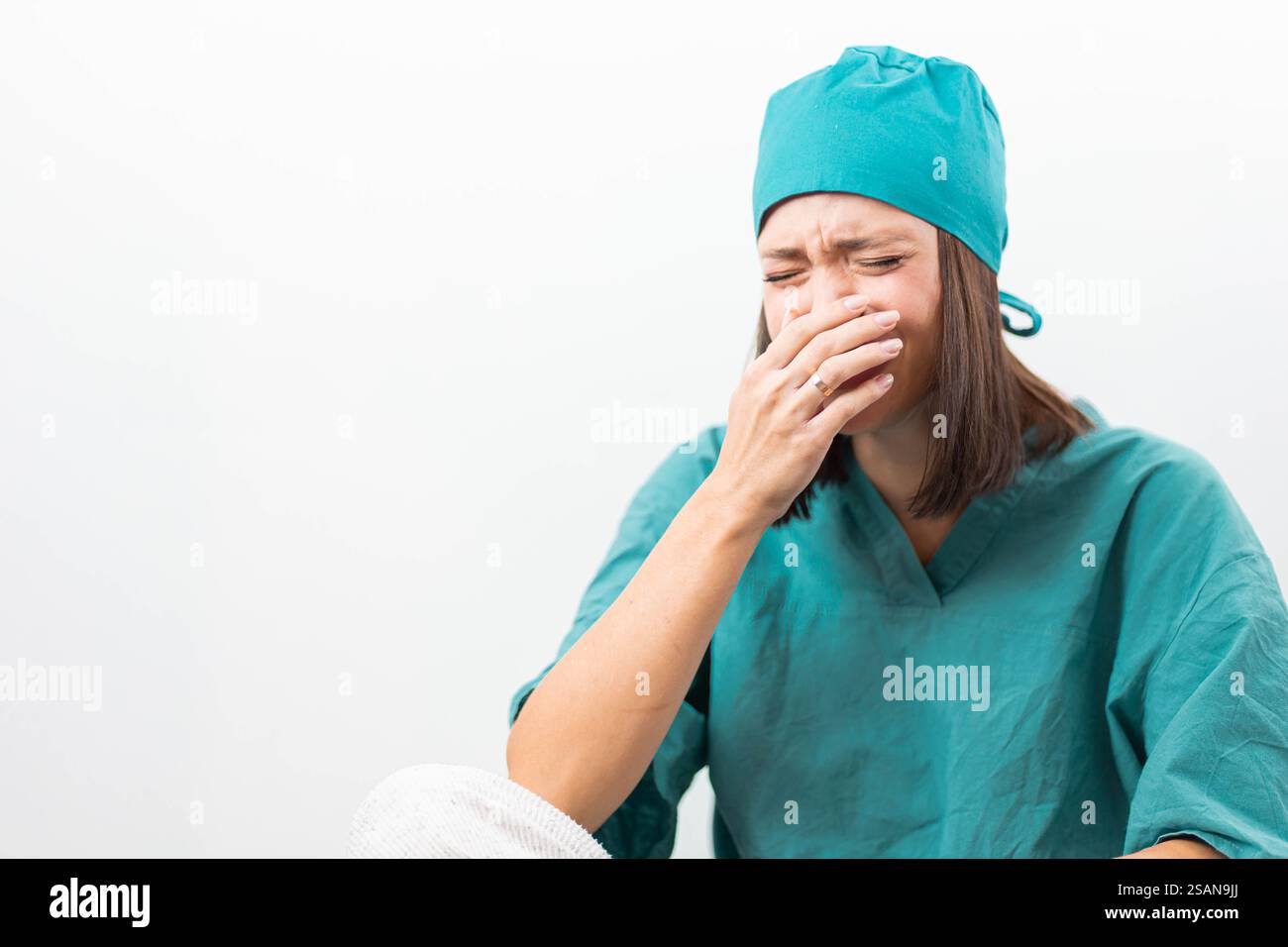 Emotional nurse in teal uniform crying on a white background Stock ...