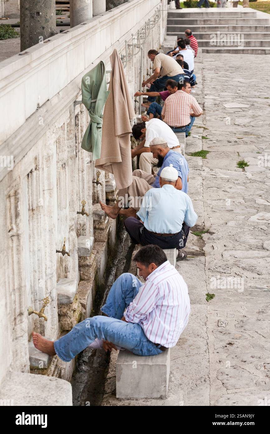 Washing Feet before Friday Prayers at the Mosque: A line of men sit on ...
