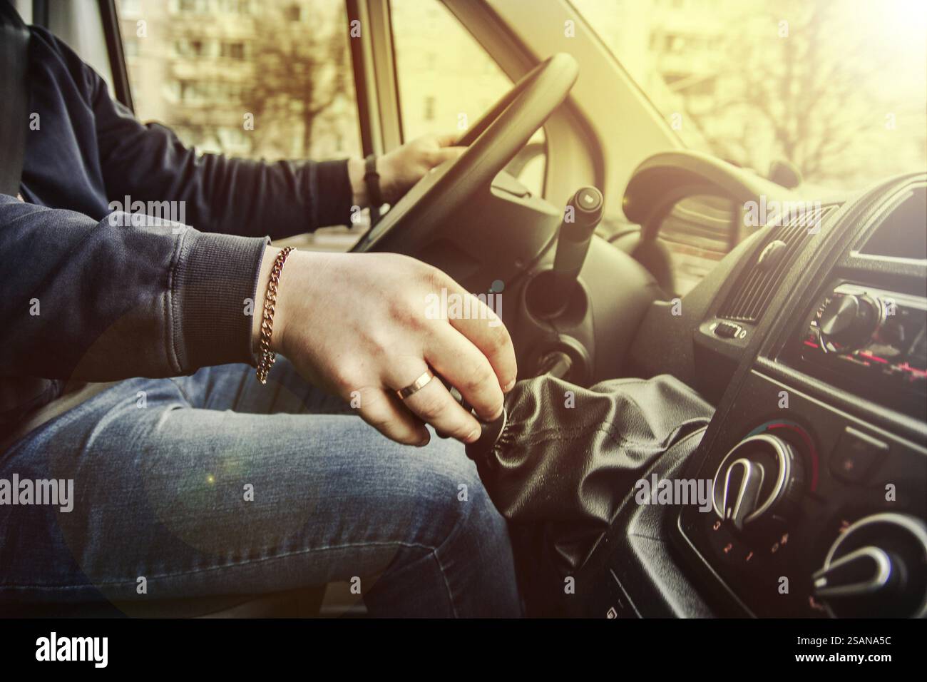 Driver handling a car with sunlight streaming through the window Stock ...
