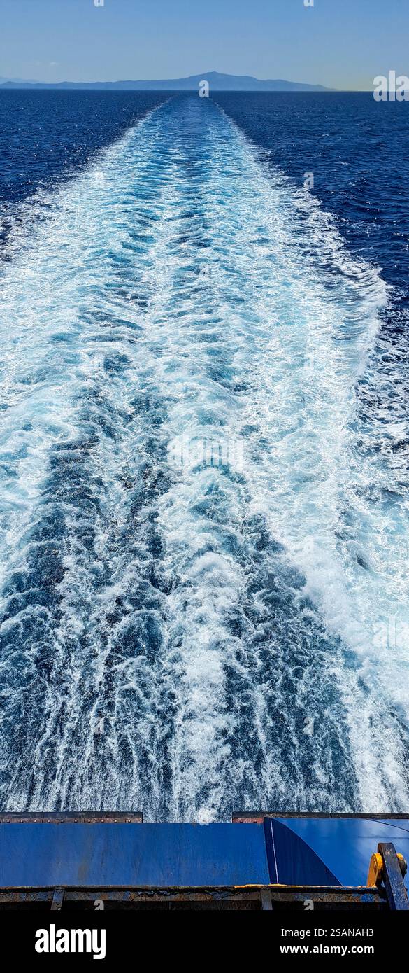 Leaving Mikinos Behind: A long white wake of churned water stretches ...