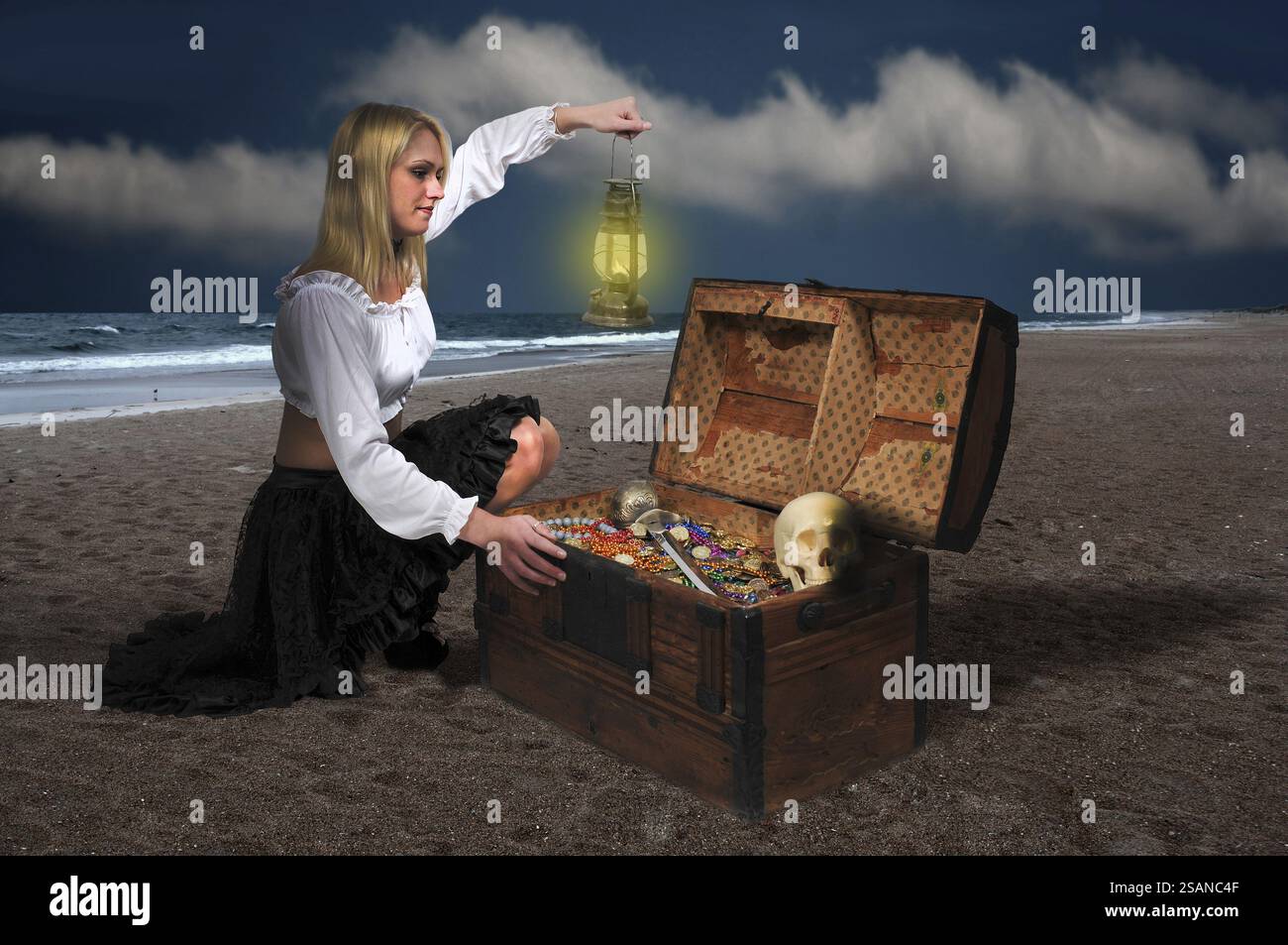 Beautiful young woman pirate opening a treasure chest Stock Photo - Alamy