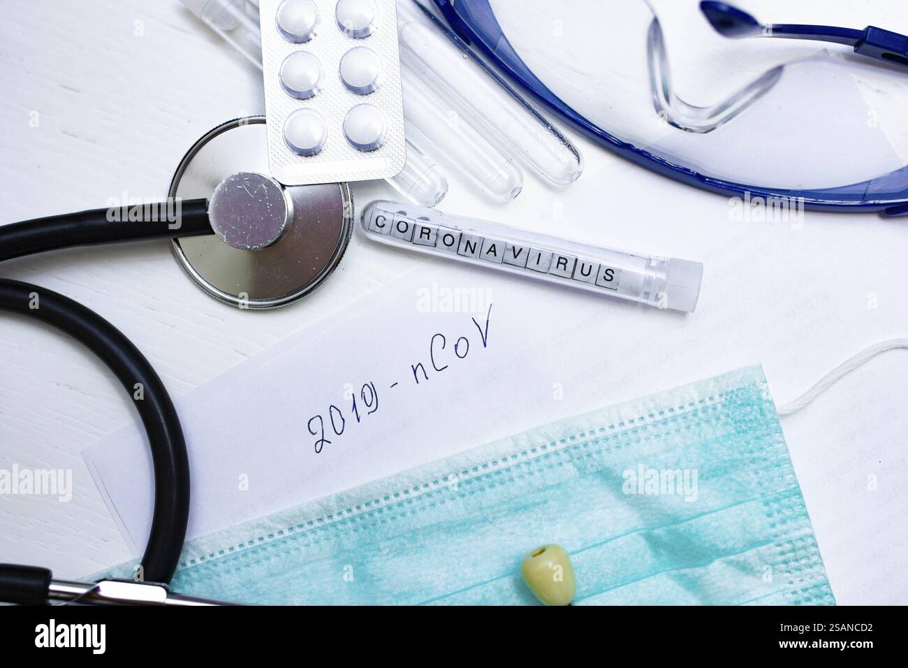 Various medical items and a 2019 nCoV labeled test tube on a table ...