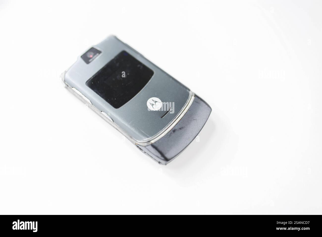 Closed Motorola flip phone emphasizing its logo and camera, in a ...