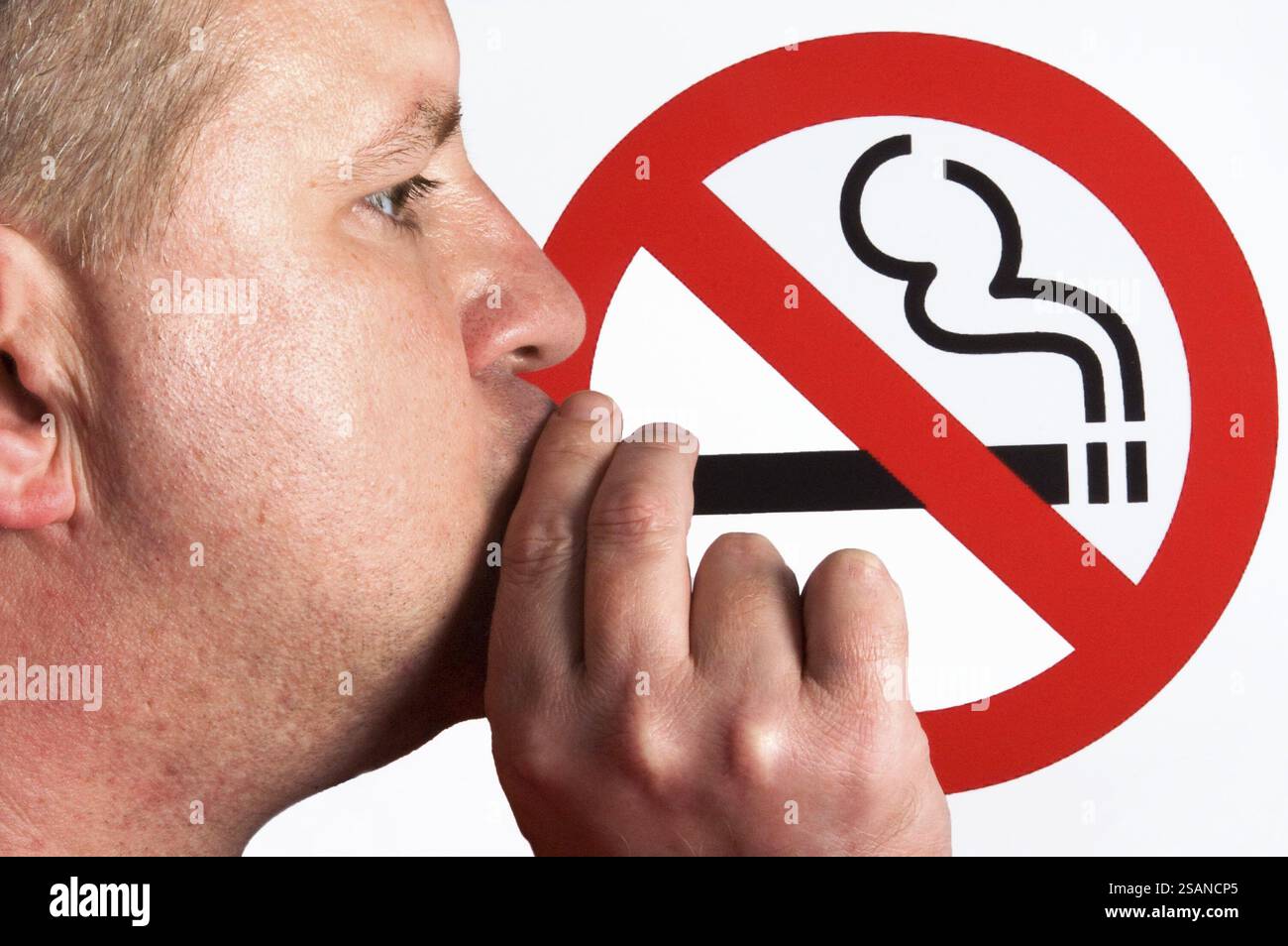 A man smoking a no smoking sign Stock Photo - Alamy