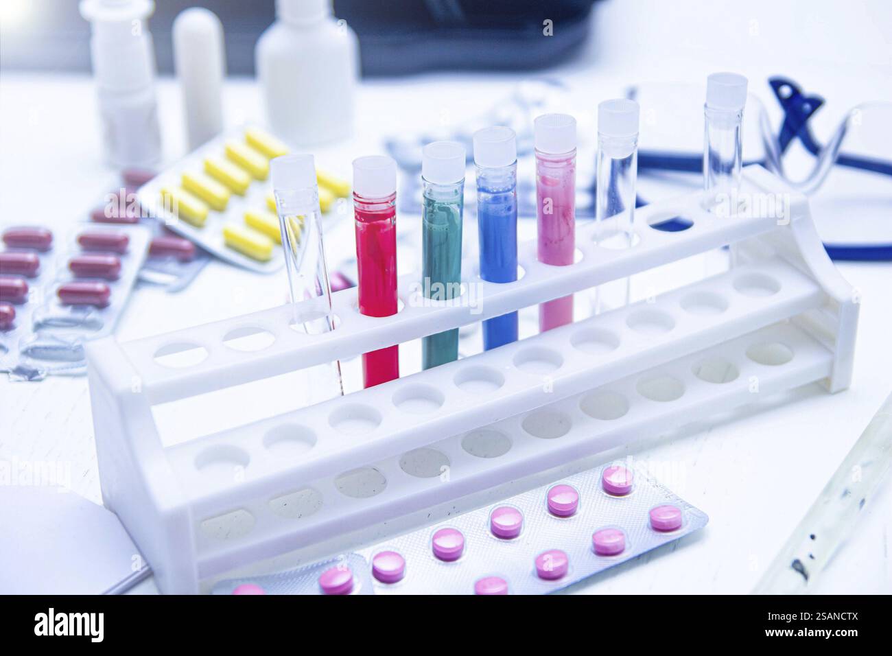 Colorful test tubes and blister packs on a laboratory surface Stock ...
