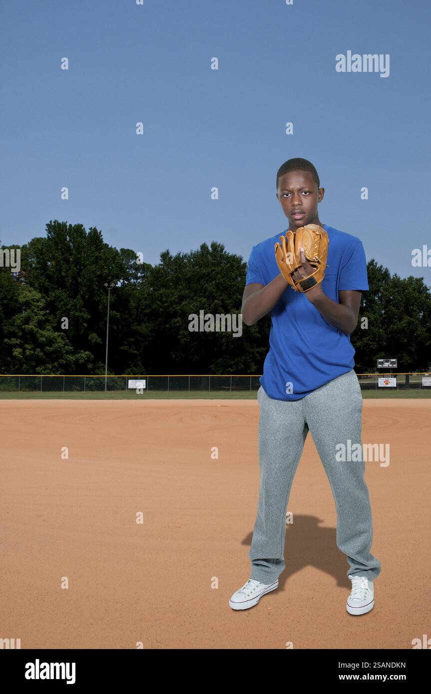 A black African American teenage man baseball pitcher getting ready to ...