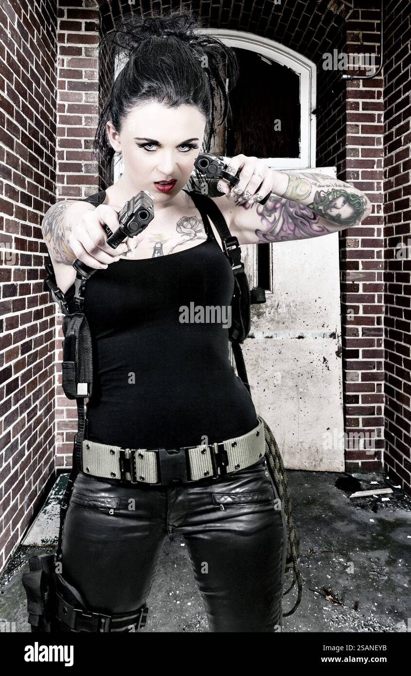 Beautiful young woman shooting things with pistols Stock Photo - Alamy