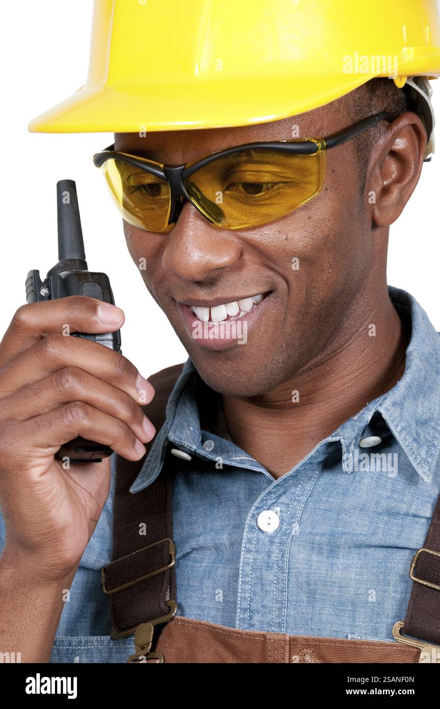 Handsome black man construction worker talking on a walkie talkie Stock ...