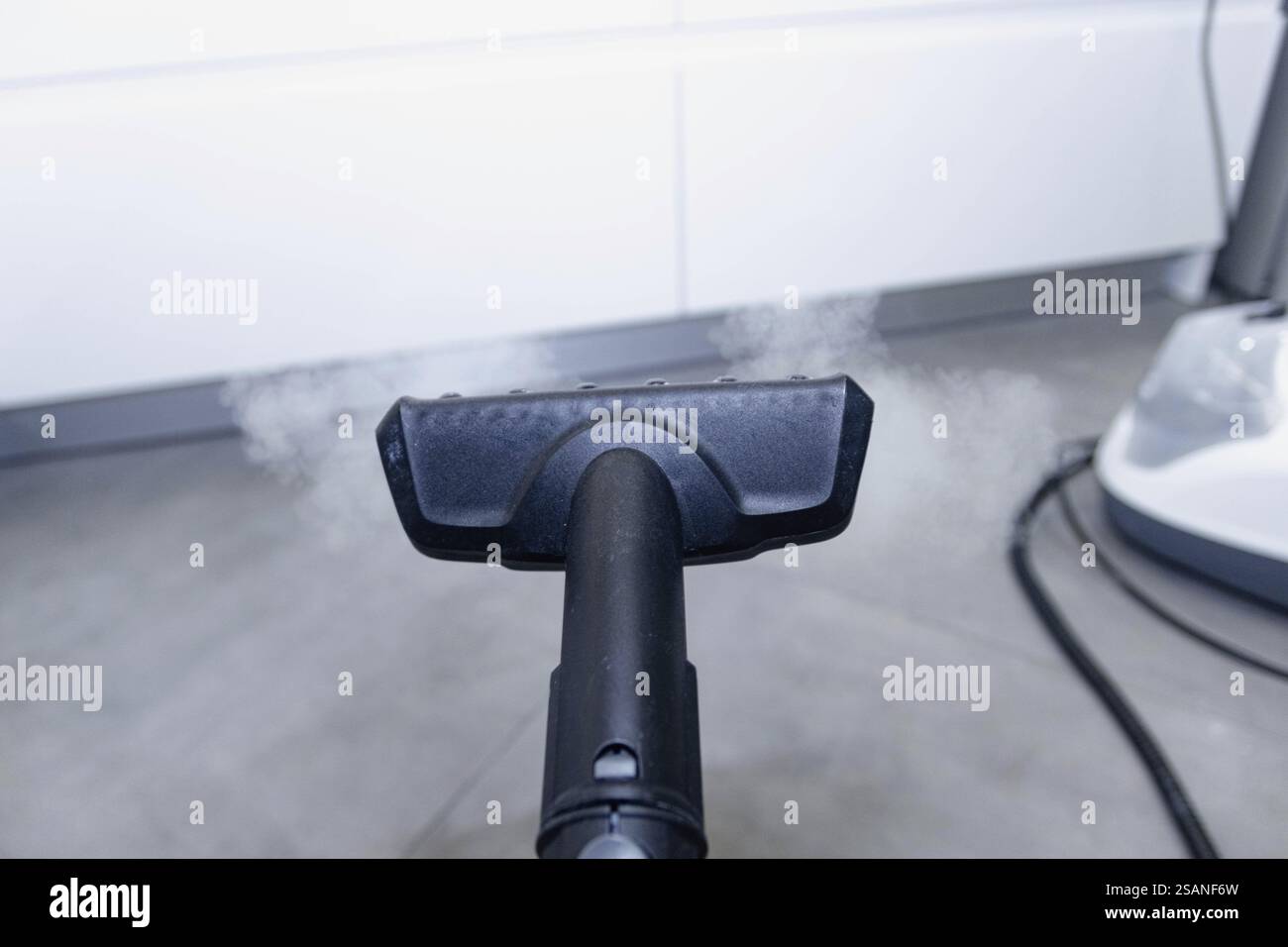 Steam cleaner emitting steam directly at a tile floor Stock Photo - Alamy
