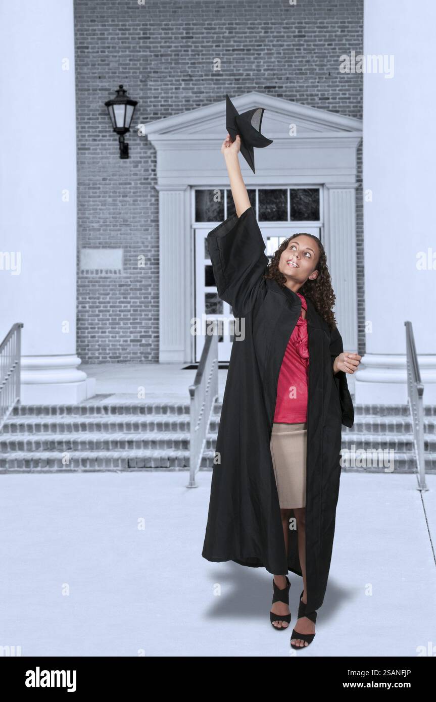 Young woman in her graduation robes throwing her cap Stock Photo - Alamy