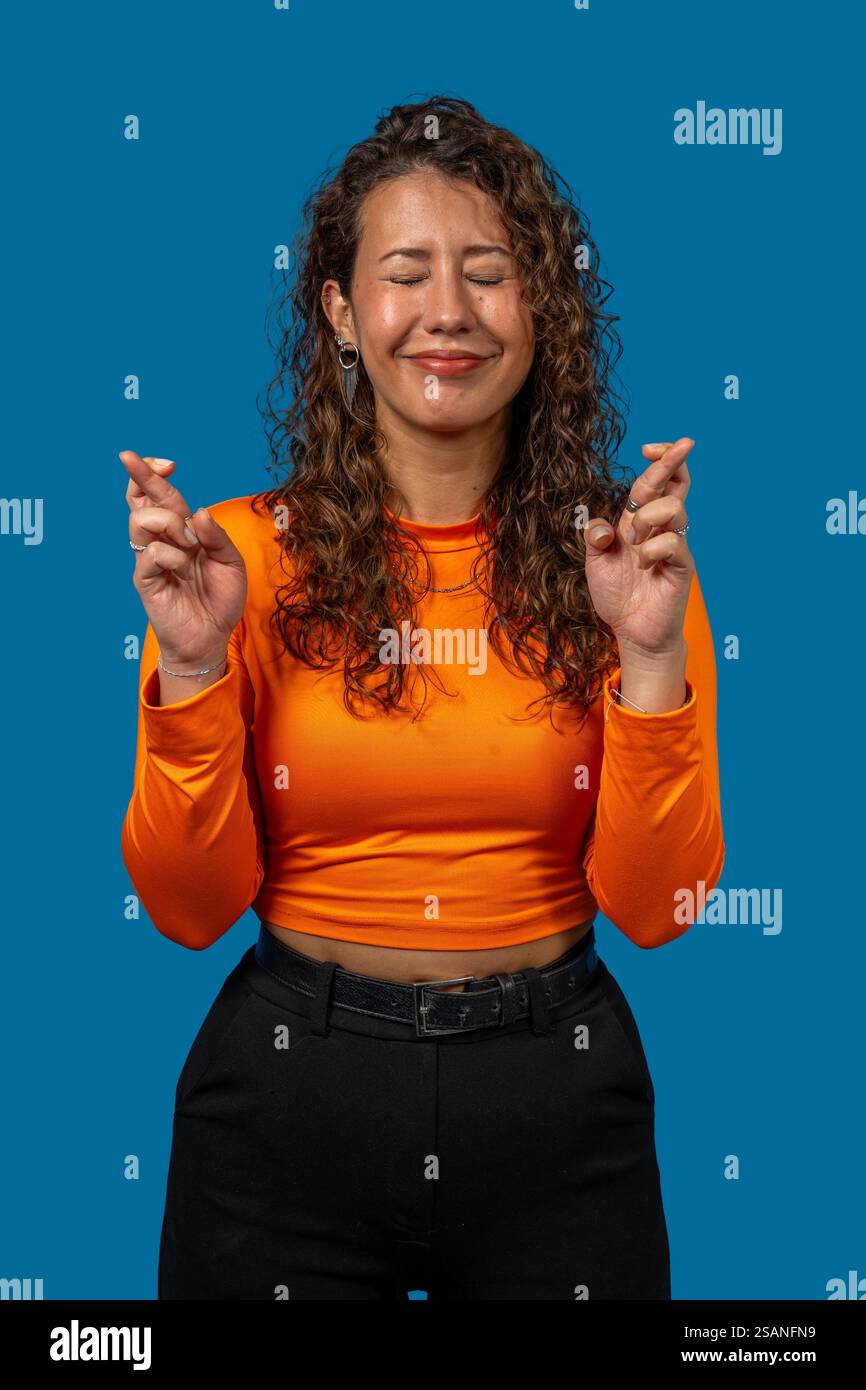 Smiling woman crossing fingers, hoping for good luck Stock Photo - Alamy