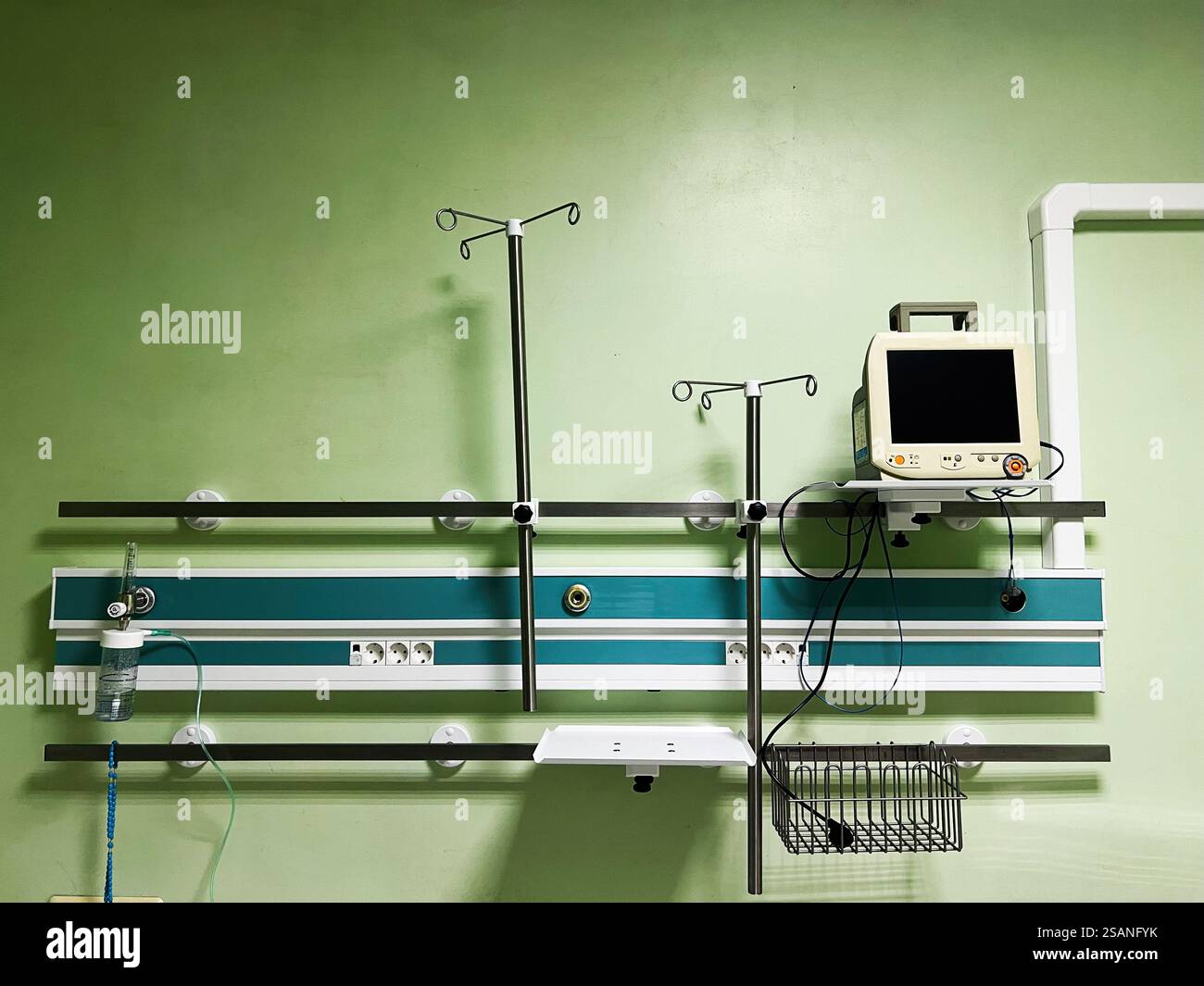 A green-painted hospital wall featuring medical equipment, such as IV ...
