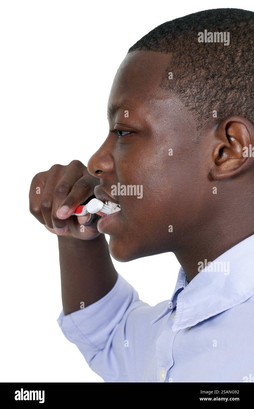 Handsome teenage boy exercising good dental hygiene by brushing his ...