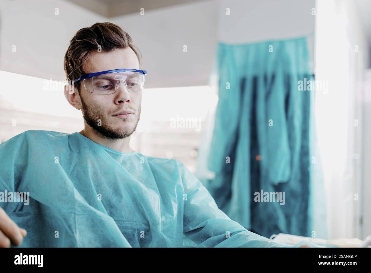 Doctor wearing saftey goggles, looking calm and focused in medical ...