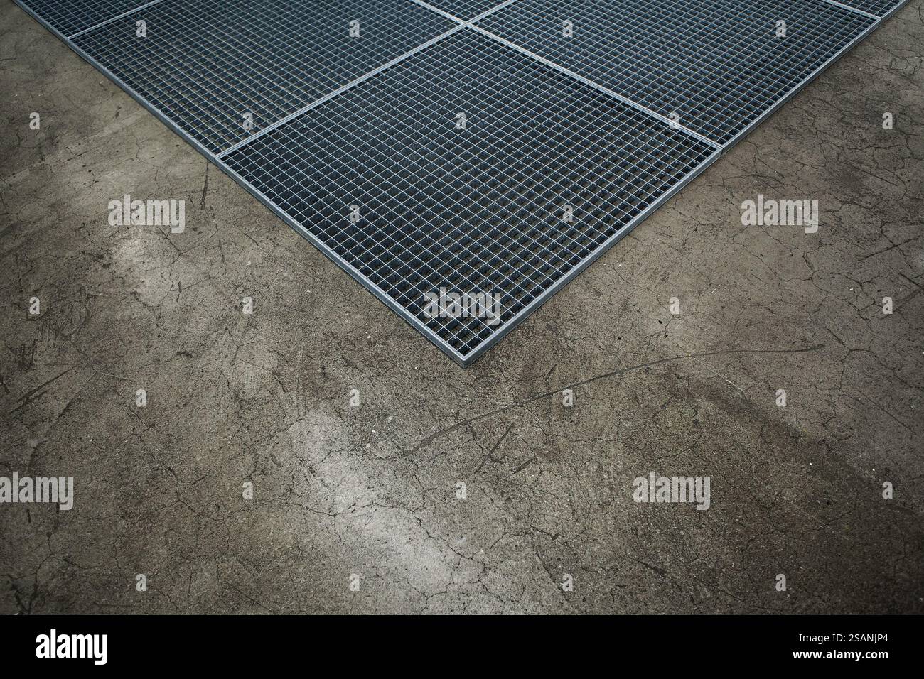 Metal grid on a concrete floor Stock Photo - Alamy