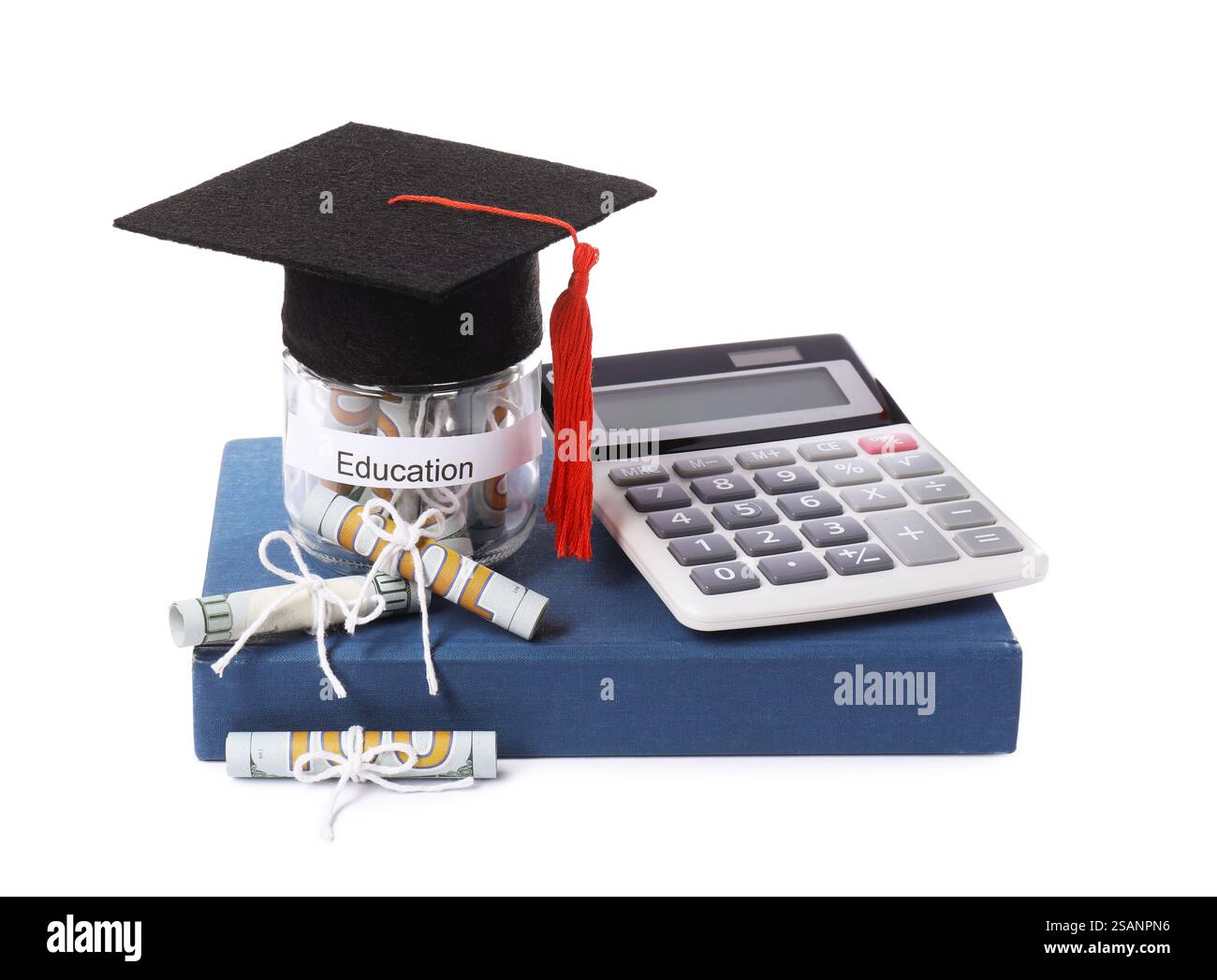Graduate hat, dollar banknotes, calculator, book and glass jar with ...