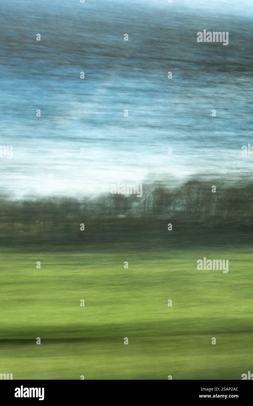 Driving through countryside in winter concept - blurred trees seen ...