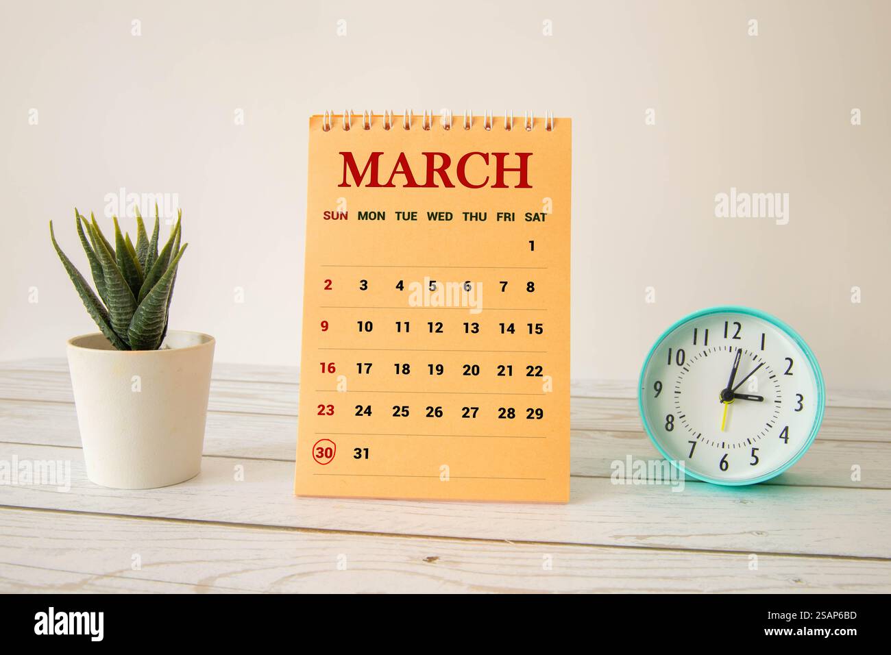 Wooden block calendar with date March 30 on blue yellow backround. Top ...