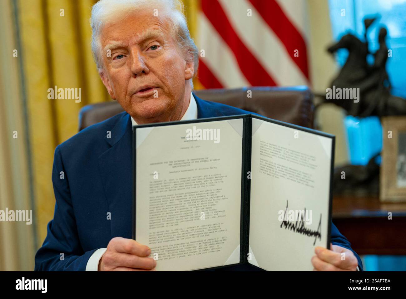 President Donald Trump signs two executive orders in the Oval Office of ...