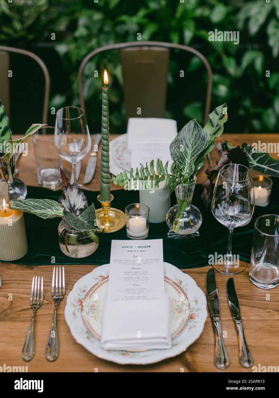 A beautifully arranged dining table features detailed place settings ...