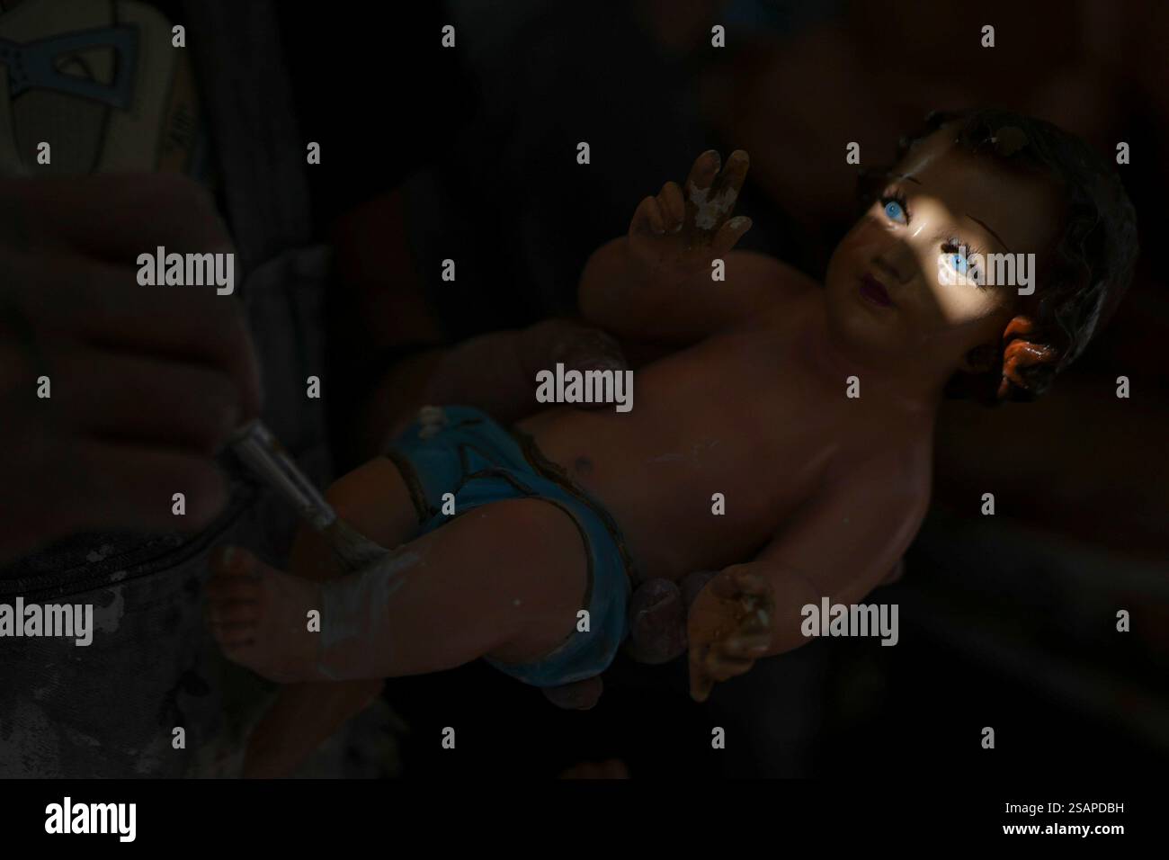 Julio Cesar repairs a figurine of Baby Jesus ahead of "Dia de la ...