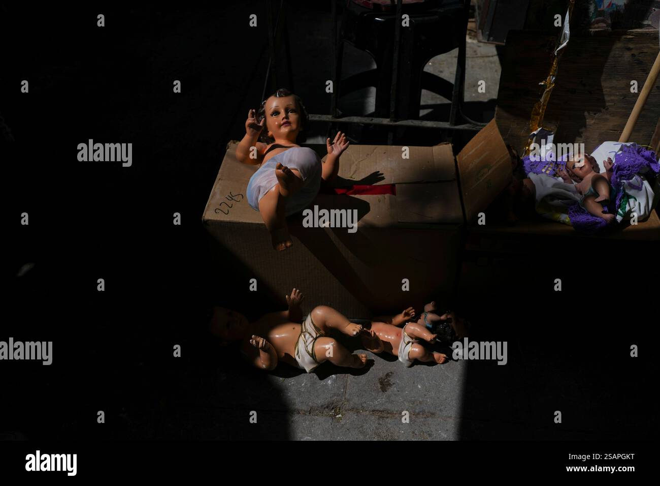 Figurines of Baby Jesus dry off in the sun after being painted in ...