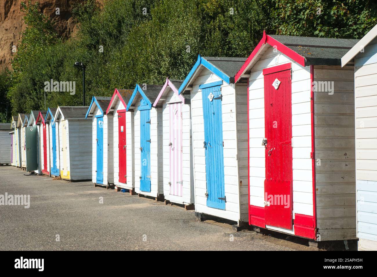 Colourful beach huts beneath cliffs on coastal path around Sandown Bay ...