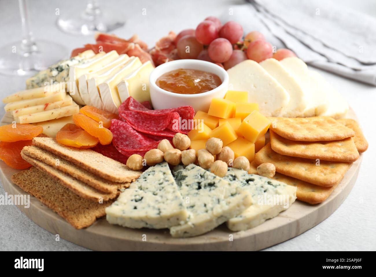 Different types of cut cheese and other snacks on light textured table ...