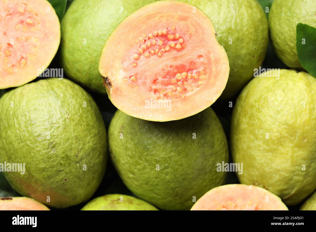 Fresh cut and whole guava fruits as background, above view Stock Photo ...