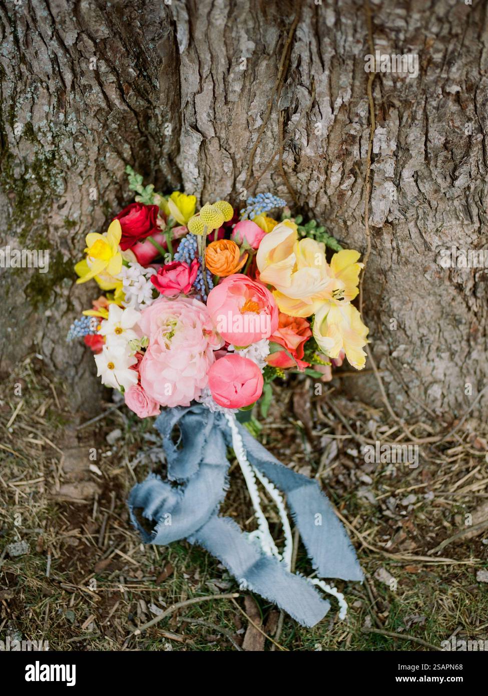 A vibrant bouquet featuring an array of flowers in various colors leans ...