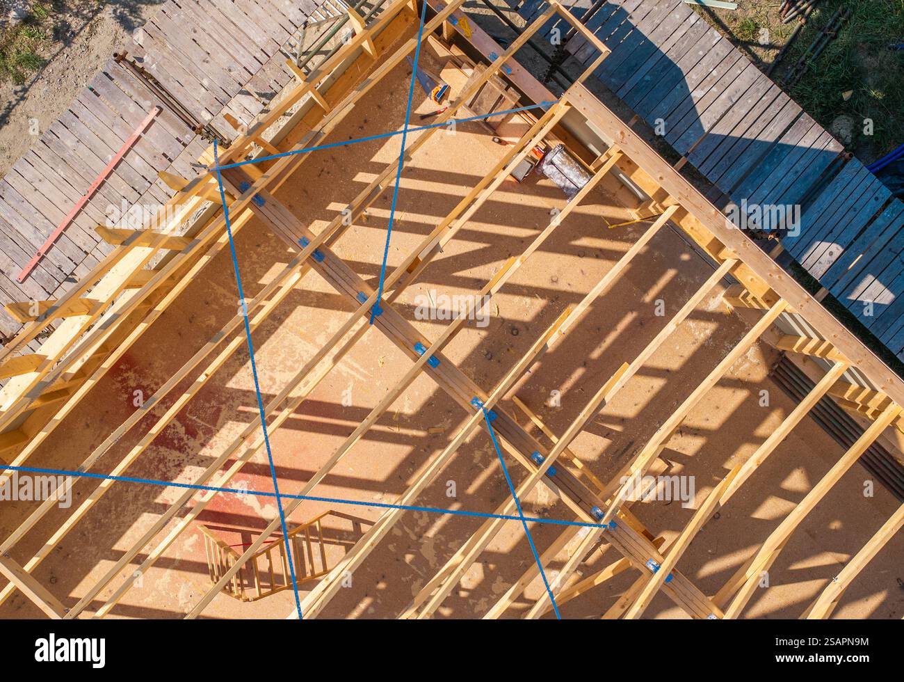 Workers are busy constructing a wooden structure, visible framing and ...