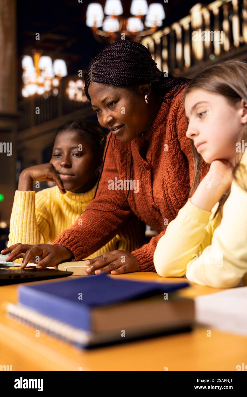African american private tutor offering support to two schoolgirls ...