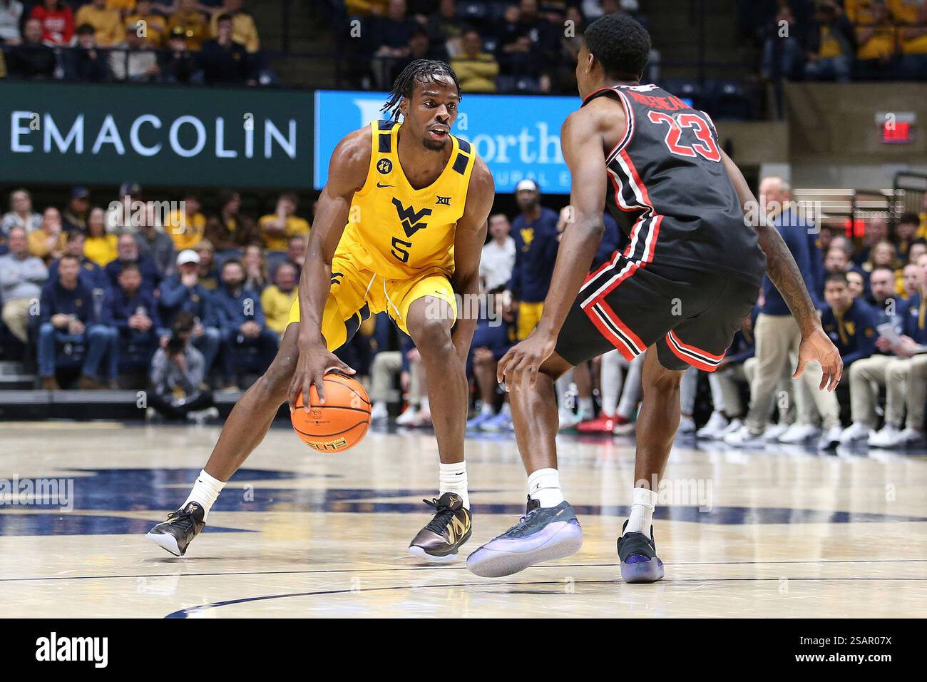 West Virginia guard Toby Okani (5) is defended by Houston guard ...