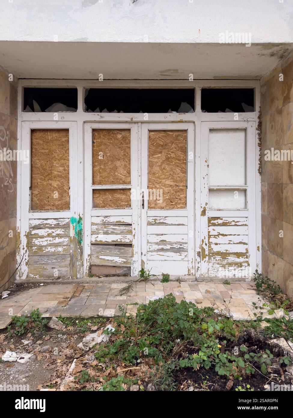 Abandoned Building Entrance with Broken and Boarded Doors, Aftermath of ...