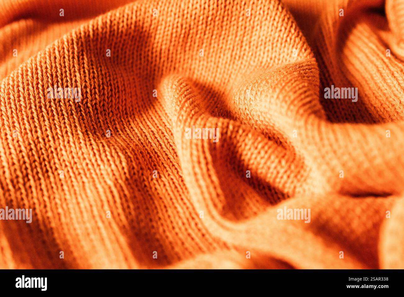 Texture of orange knitted fabric with waves and selective blur.Spring ...