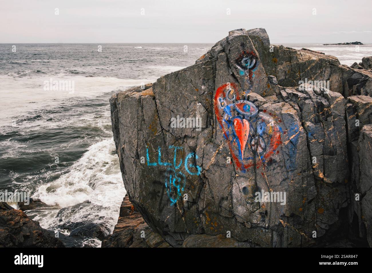 Large rock covered in colorful graffiti along coast Stock Photo - Alamy