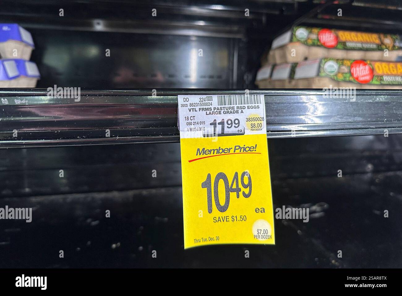 A sale tag hangs from the empty shelf of a refrigerated case used to ...
