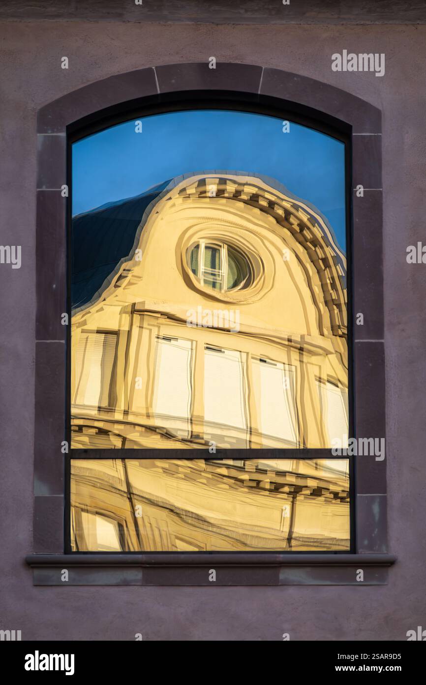 A distorted reflection of a historic building in a window in Colmar ...