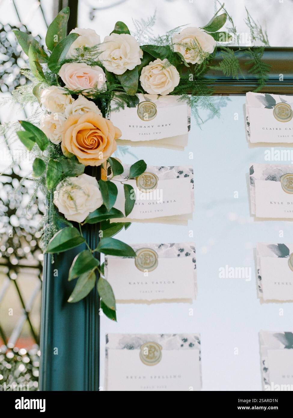A beautifully arranged seating chart features delicate white and peach ...
