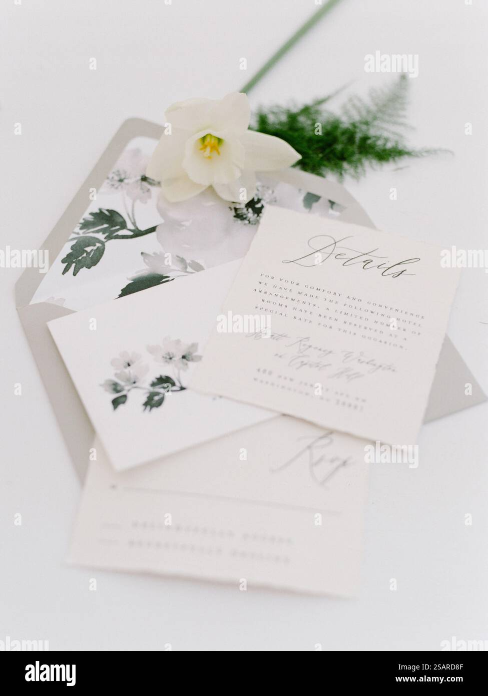A beautiful wedding invitation suite is displayed on a soft surface ...