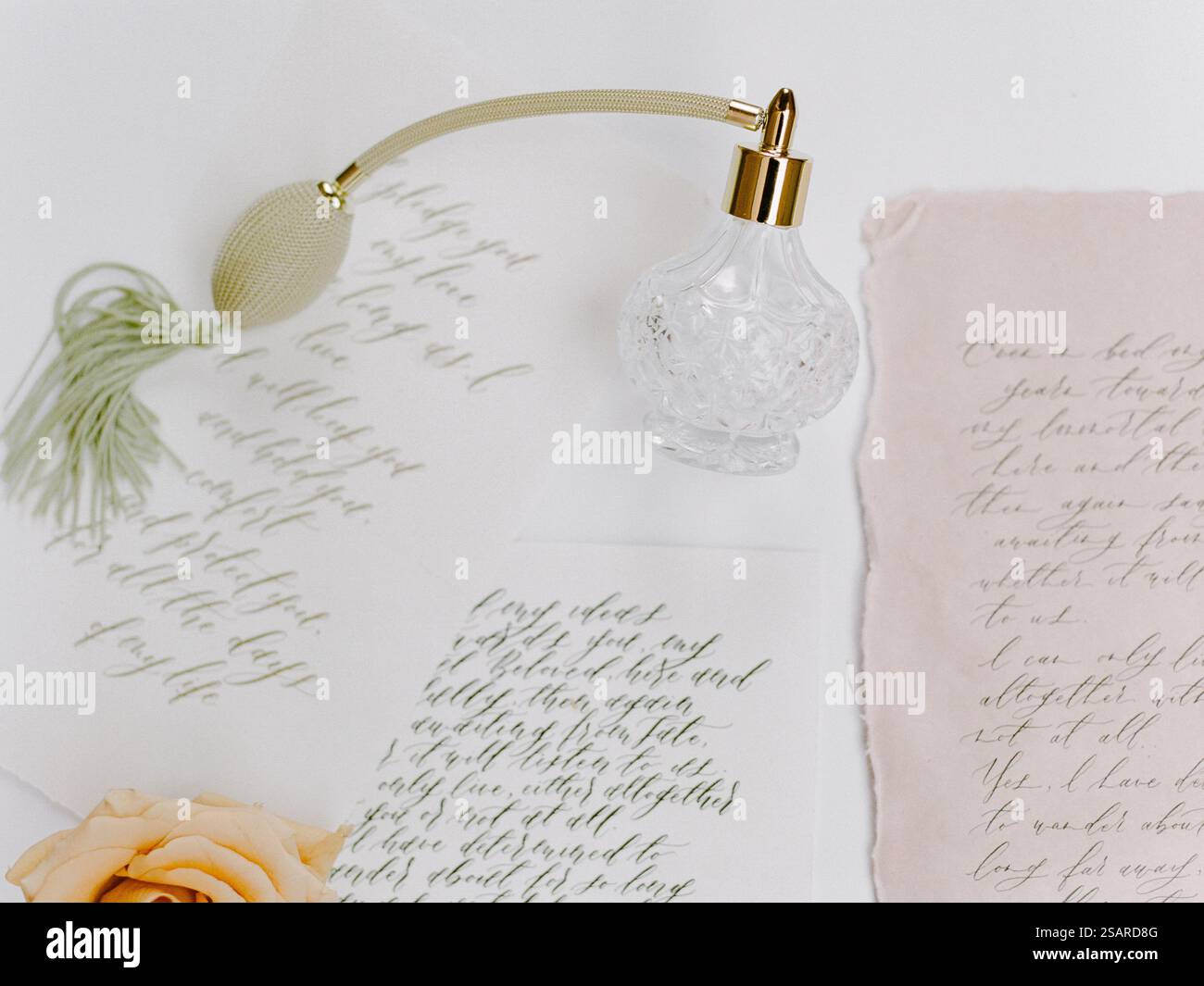 Delicate handwritten letters and a vintage perfume spray bottle are ...