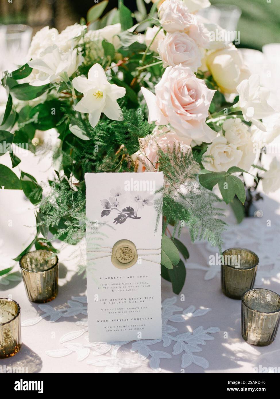 A beautifully arranged table features a floral centerpiece with soft ...