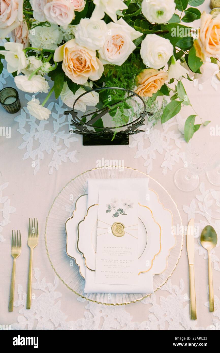 A beautifully arranged dining table features golden cutlery and an ...