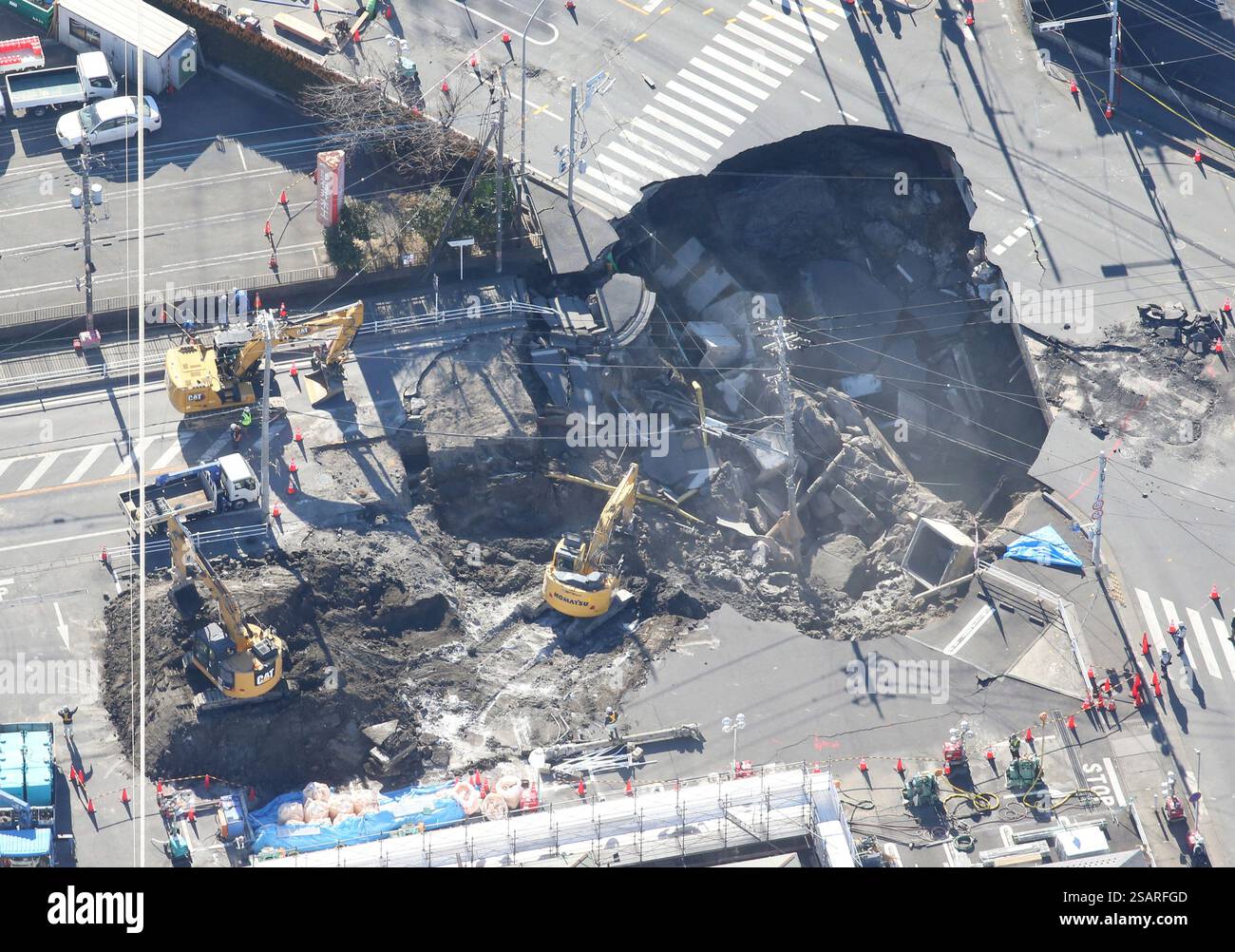 An aerial photo shows sinkholes at an intersection in Yashio City ...