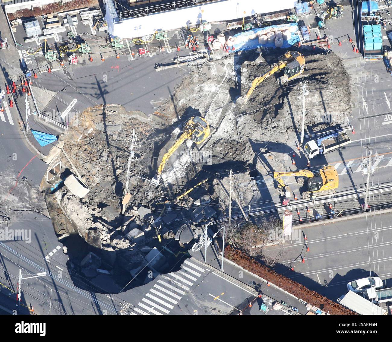 An aerial photo shows sinkholes at an intersection in Yashio City ...