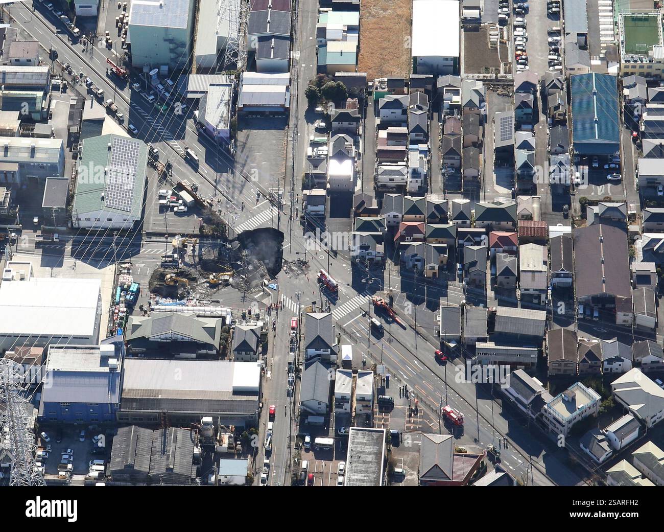 An aerial photo shows sinkholes at an intersection in Yashio City ...