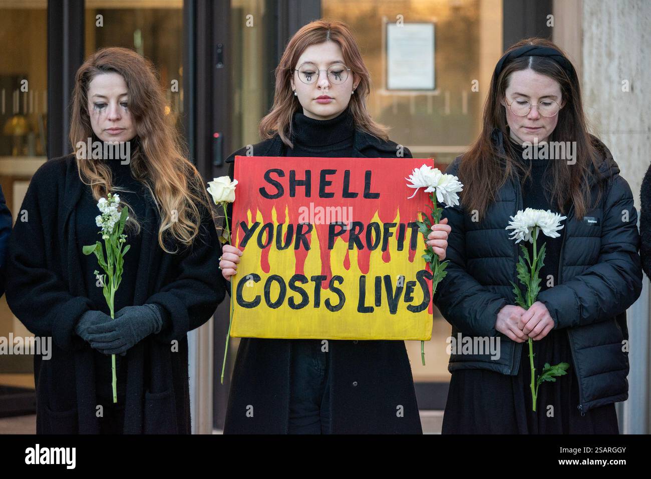 London, UK. 30th Jan, 2025. Activists stand with flowers and with a ...