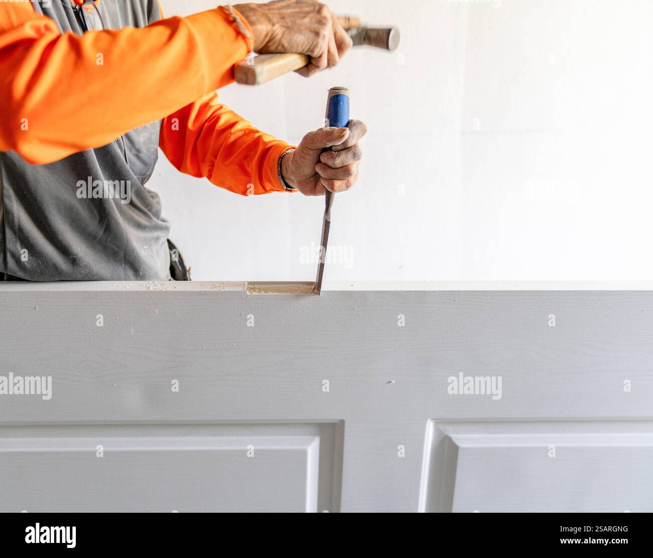 The carpenter use chisel for lock of door hinge in a new room Stock ...