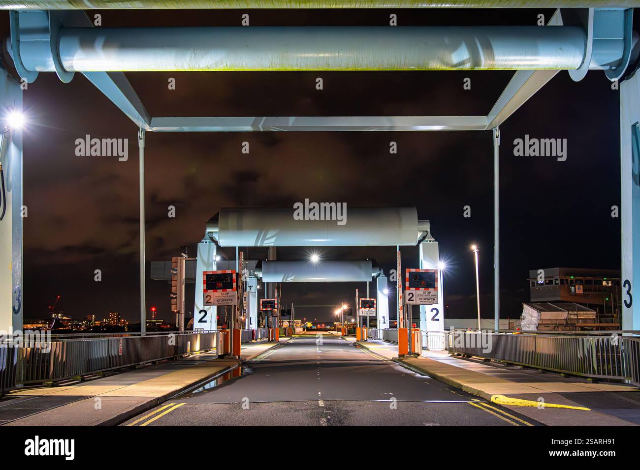 Empty road crossing Cardiff barrage control room at night, illuminated ...
