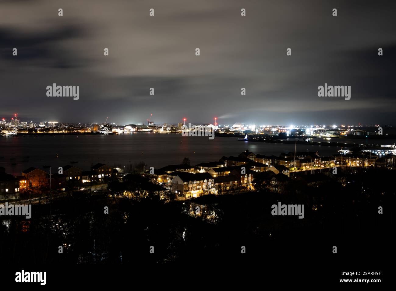 Night aerial view of Cardiff city center with its lights reflecting on ...